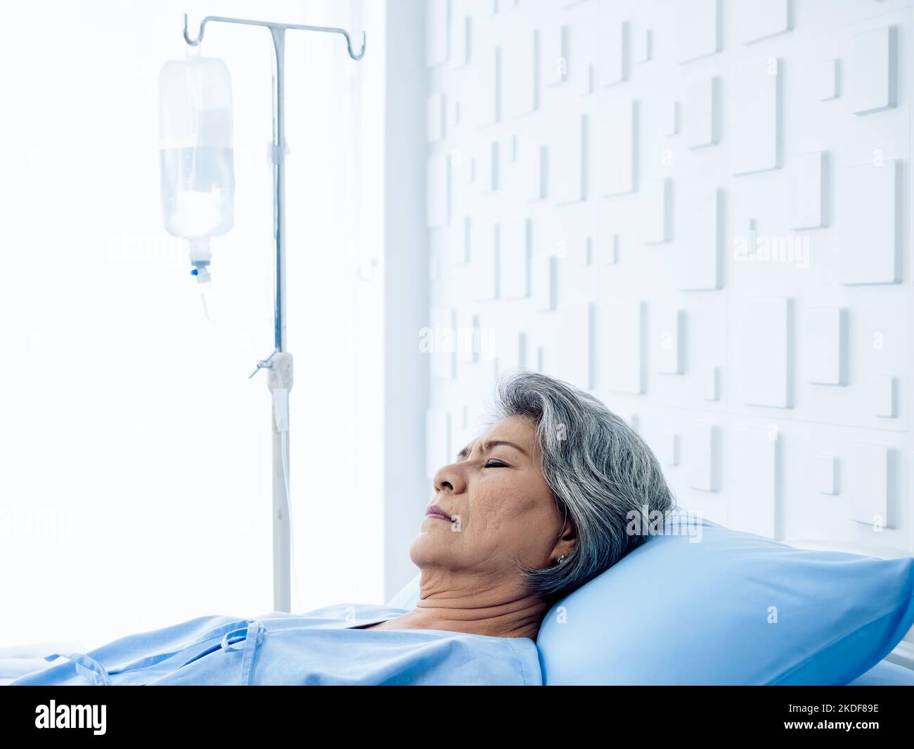 Asian senior woman patient grey hair sleeping on bed in modern white ...