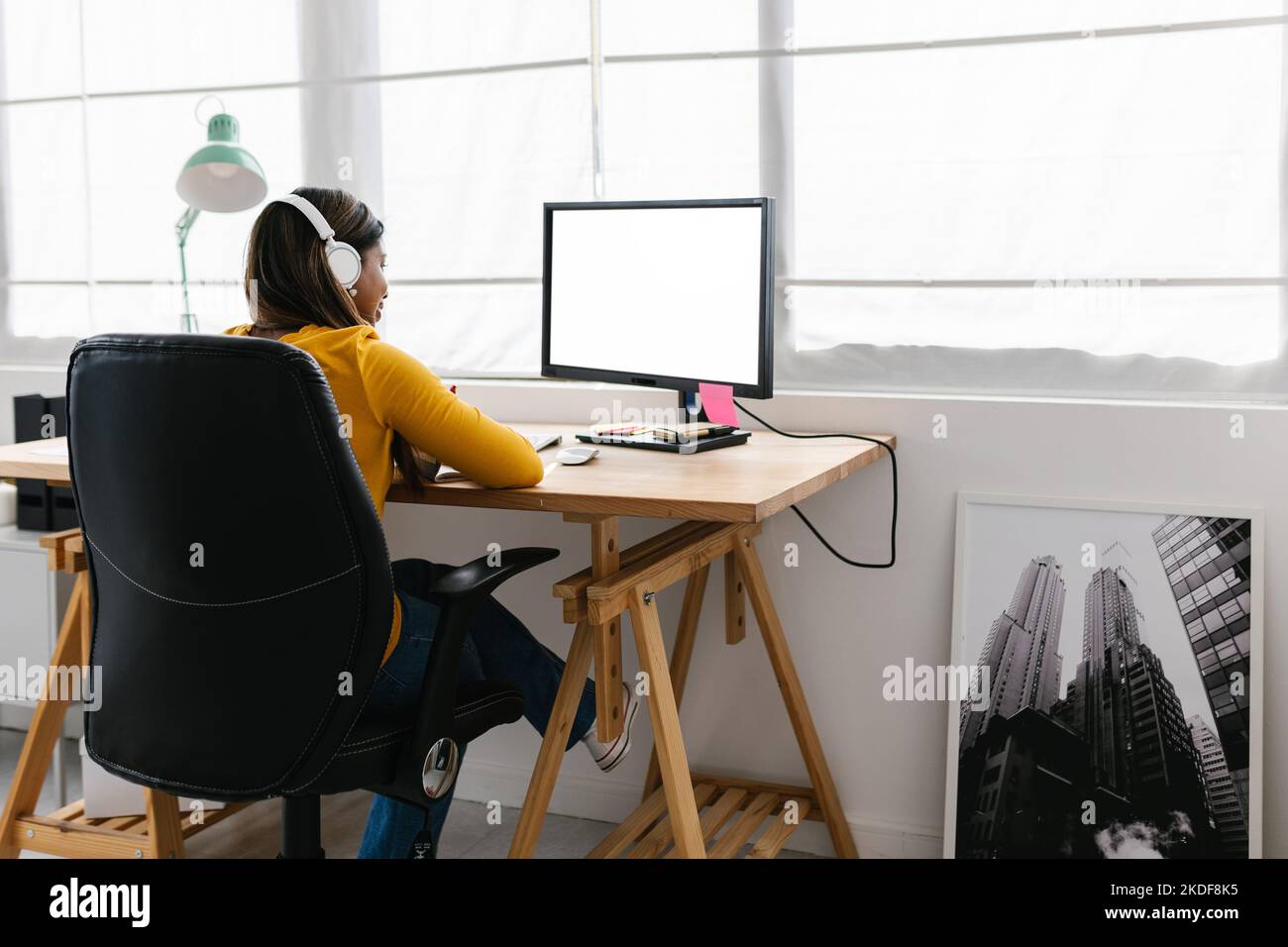 Young african american woman working on monitor with white blank screen ...