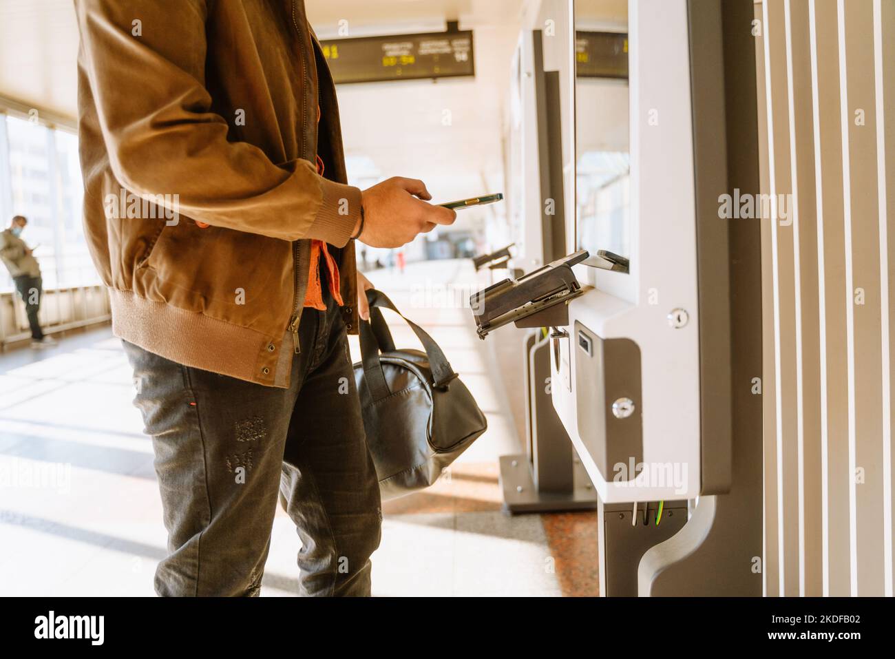 Indian man buying ticket with cellphone at train station indoors Stock ...