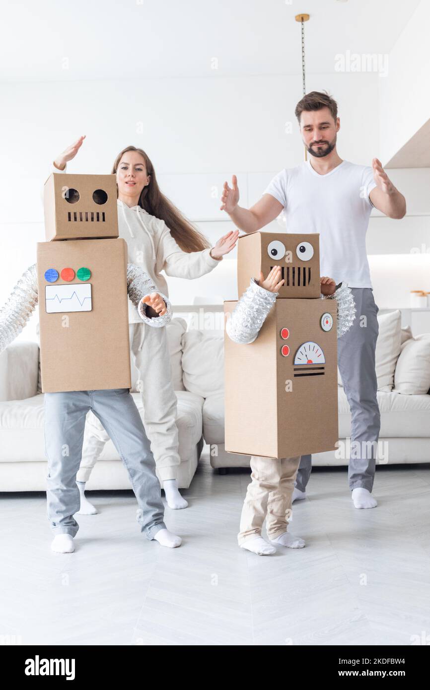 Happy family of parents and two children playing dancing like robots at ...