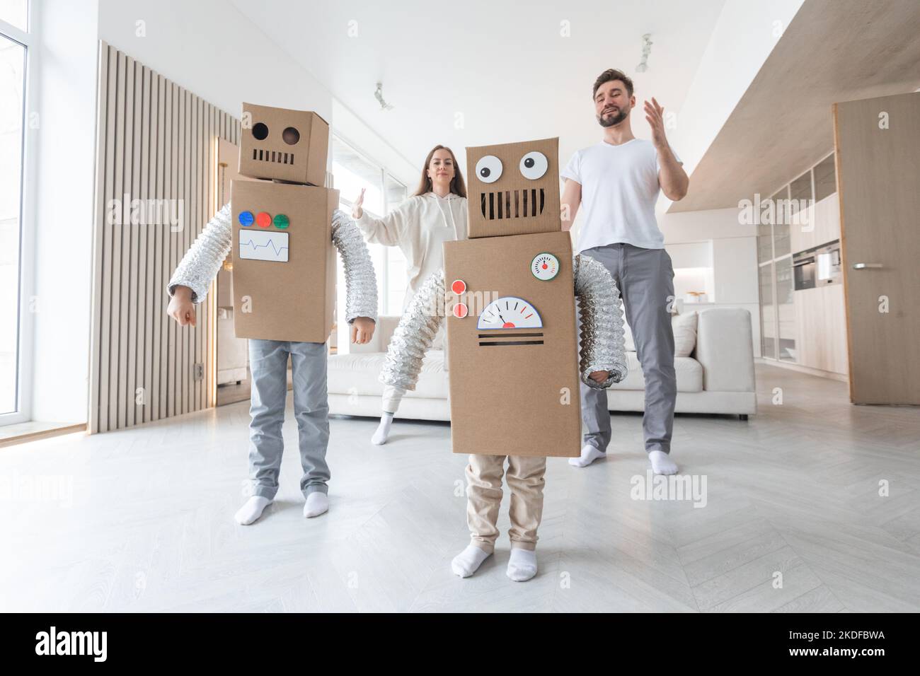 Happy family of parents and two children playing dancing like robots at ...