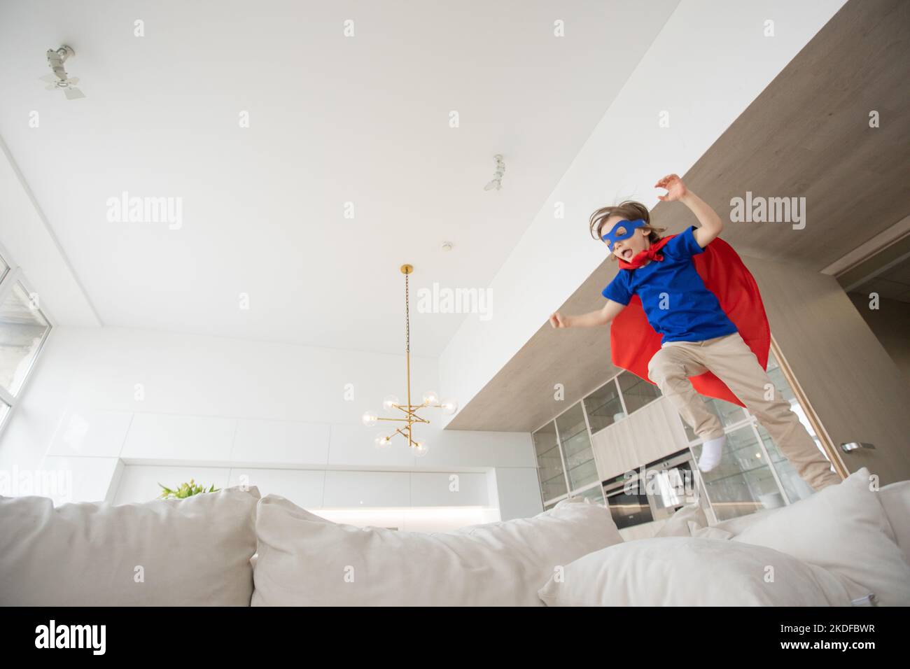 Very excited little girl dressed like superhero jumping alongside the ...