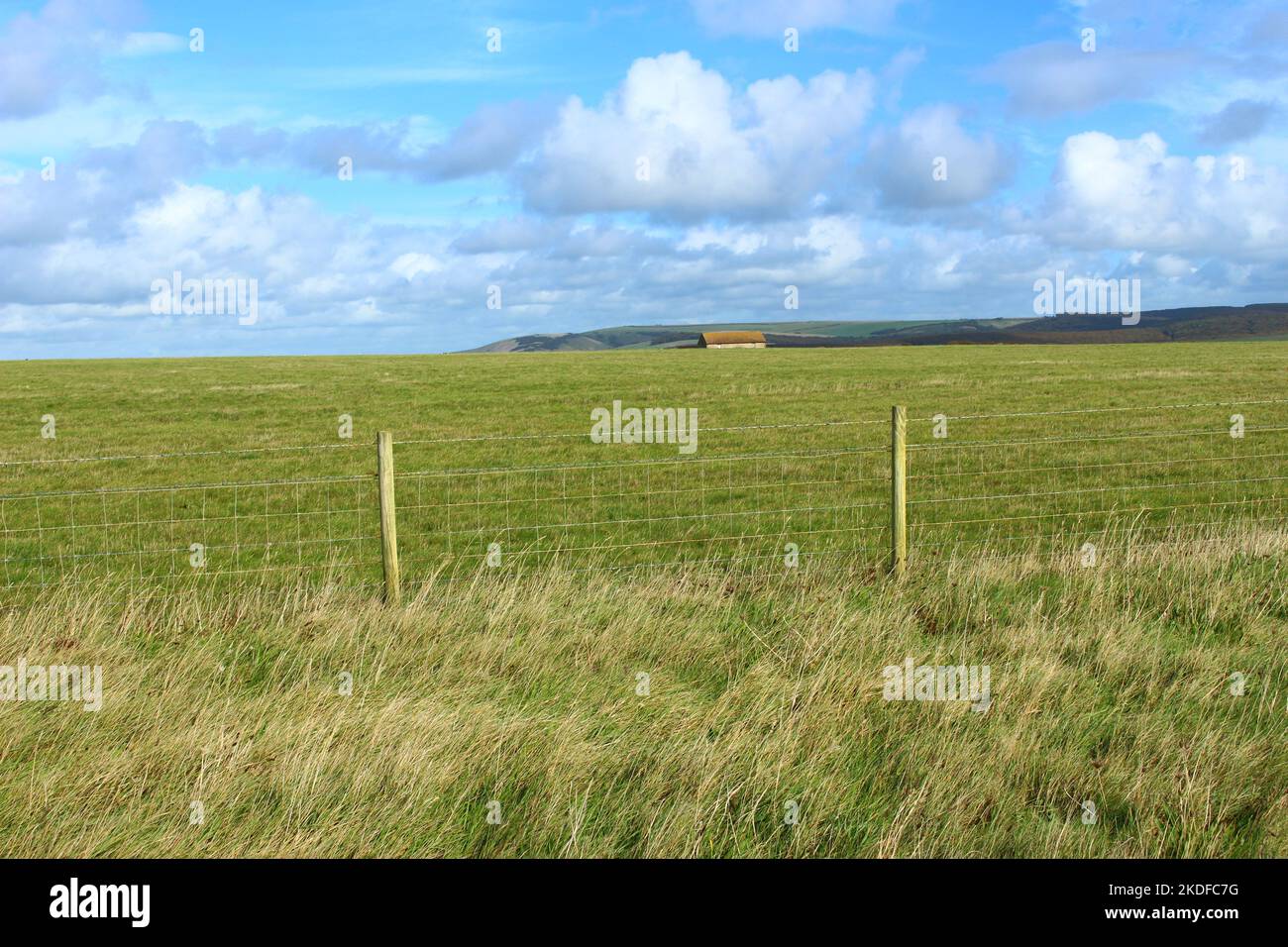 Lonely, solo farm house out alone in the middle of a green field with ...