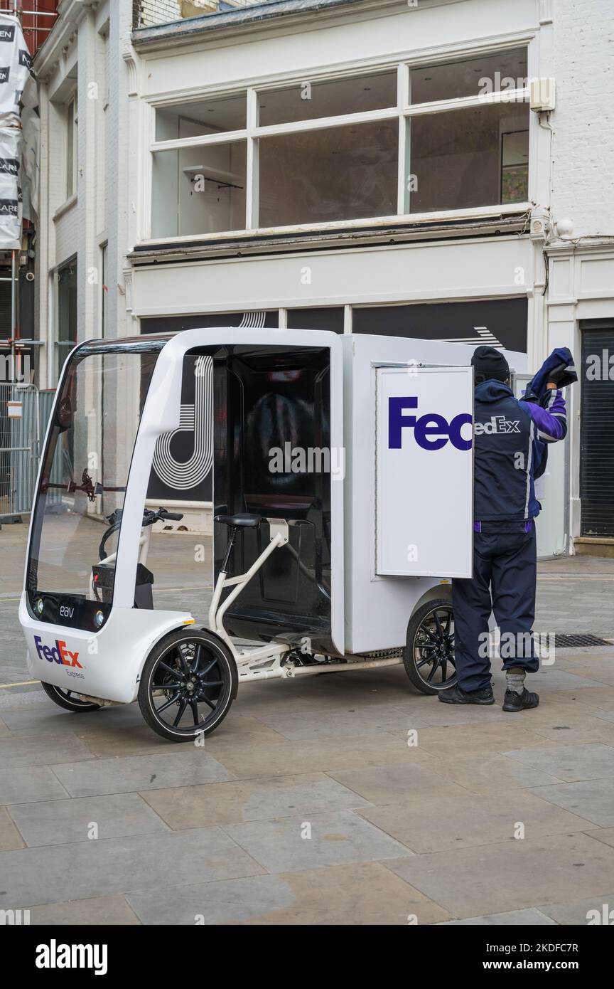 Operative unloading a delivery from a FedEx electric delivery vehicle ...
