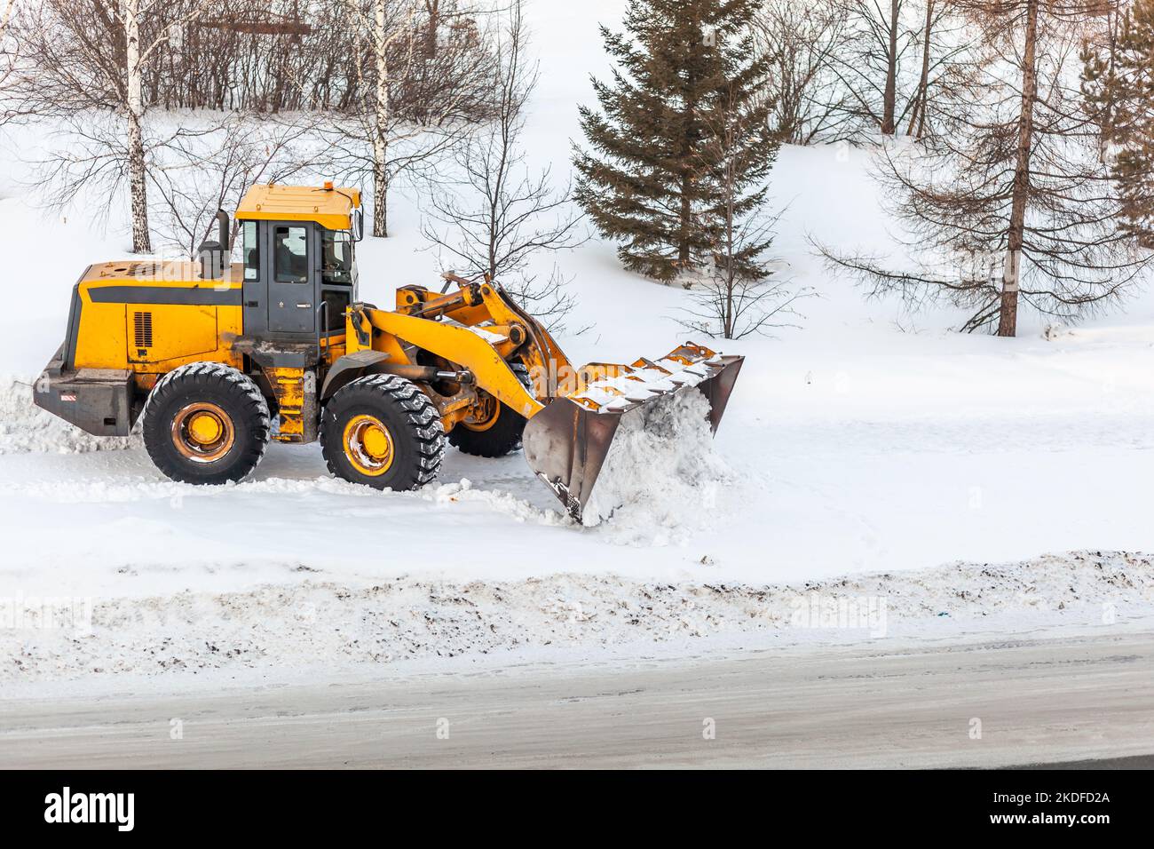 Snow clearing. Tractor clears the way after heavy snowfall. A large ...