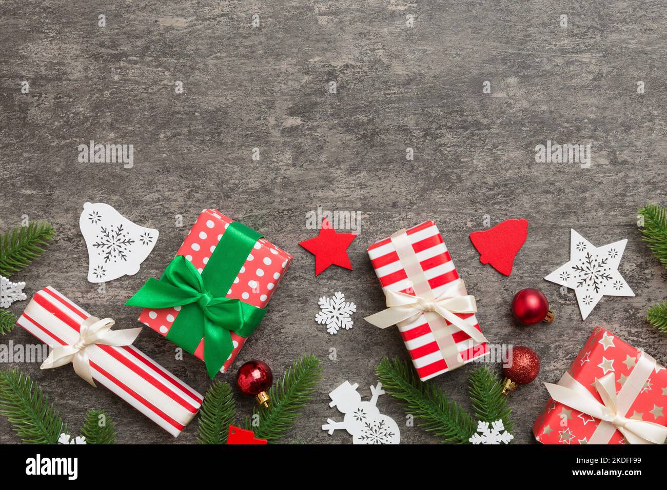 Christmas decorations and fir tree branch and gift boxon dark table ...