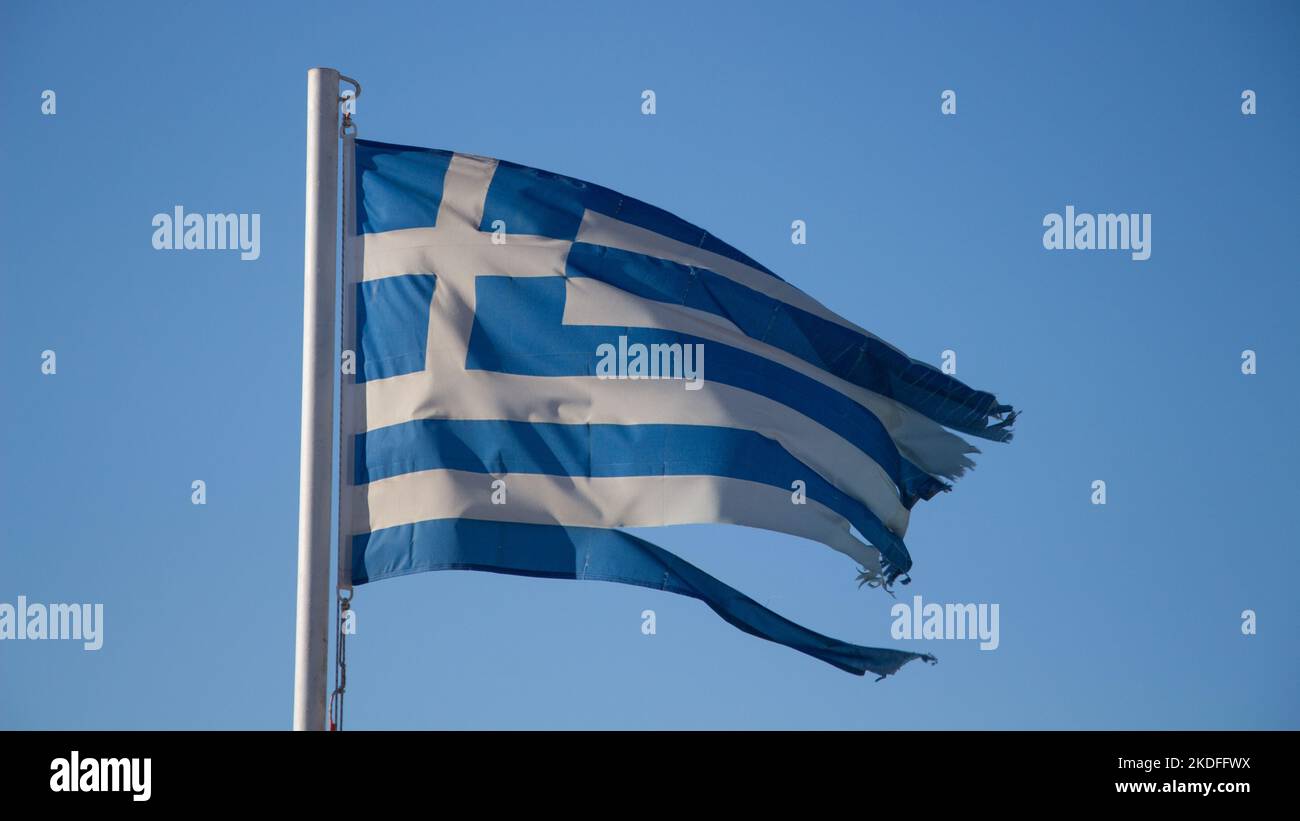 A closeup shot of the flag of Greece waving on the pole against the ...