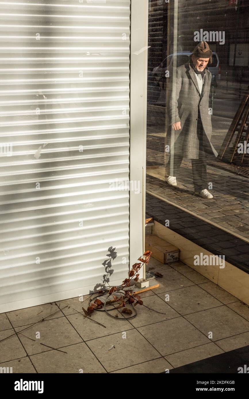 Passerby seen through the corner window of a closed store. Bunch of ...