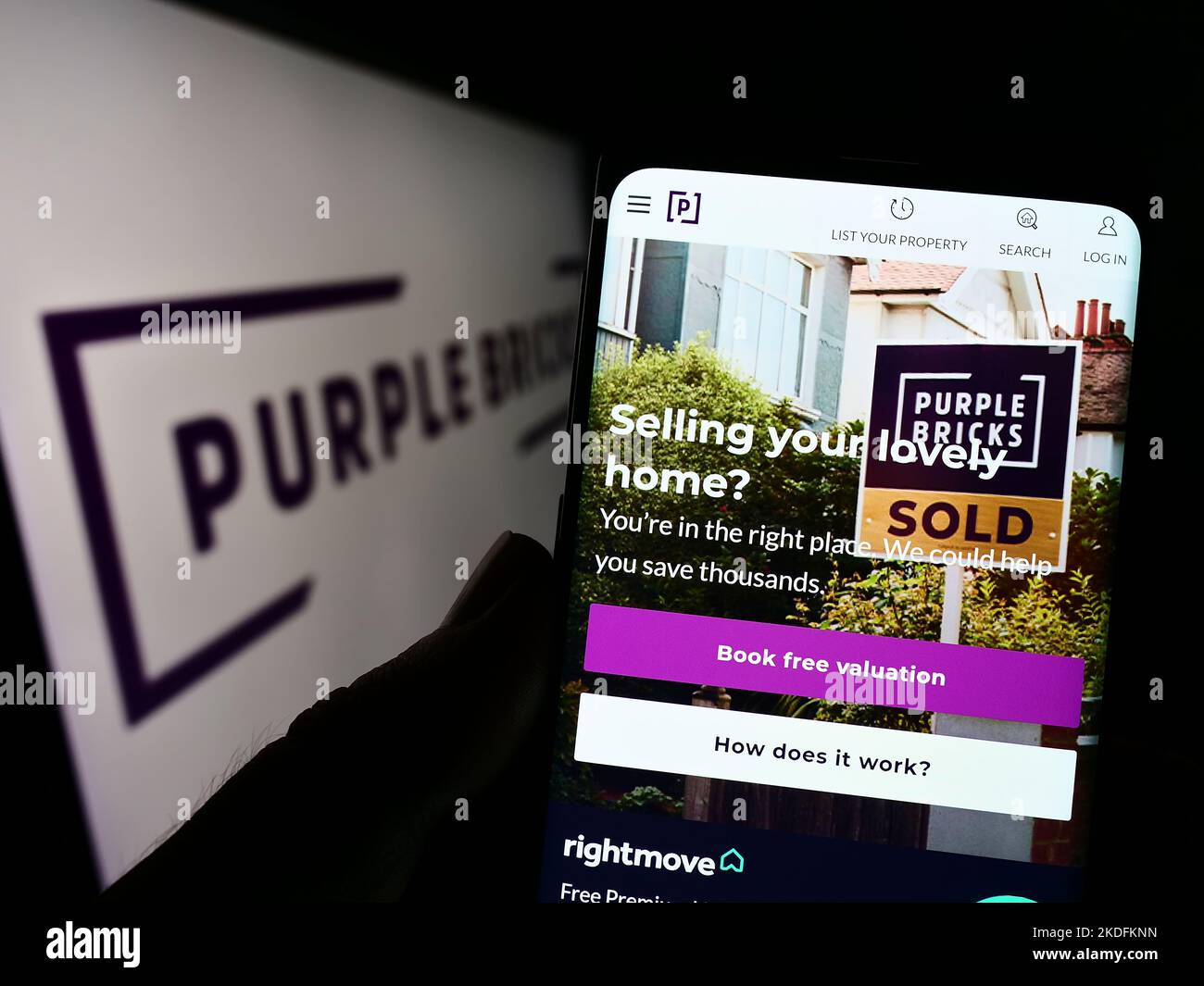 Person holding cellphone with website of real estate company ...