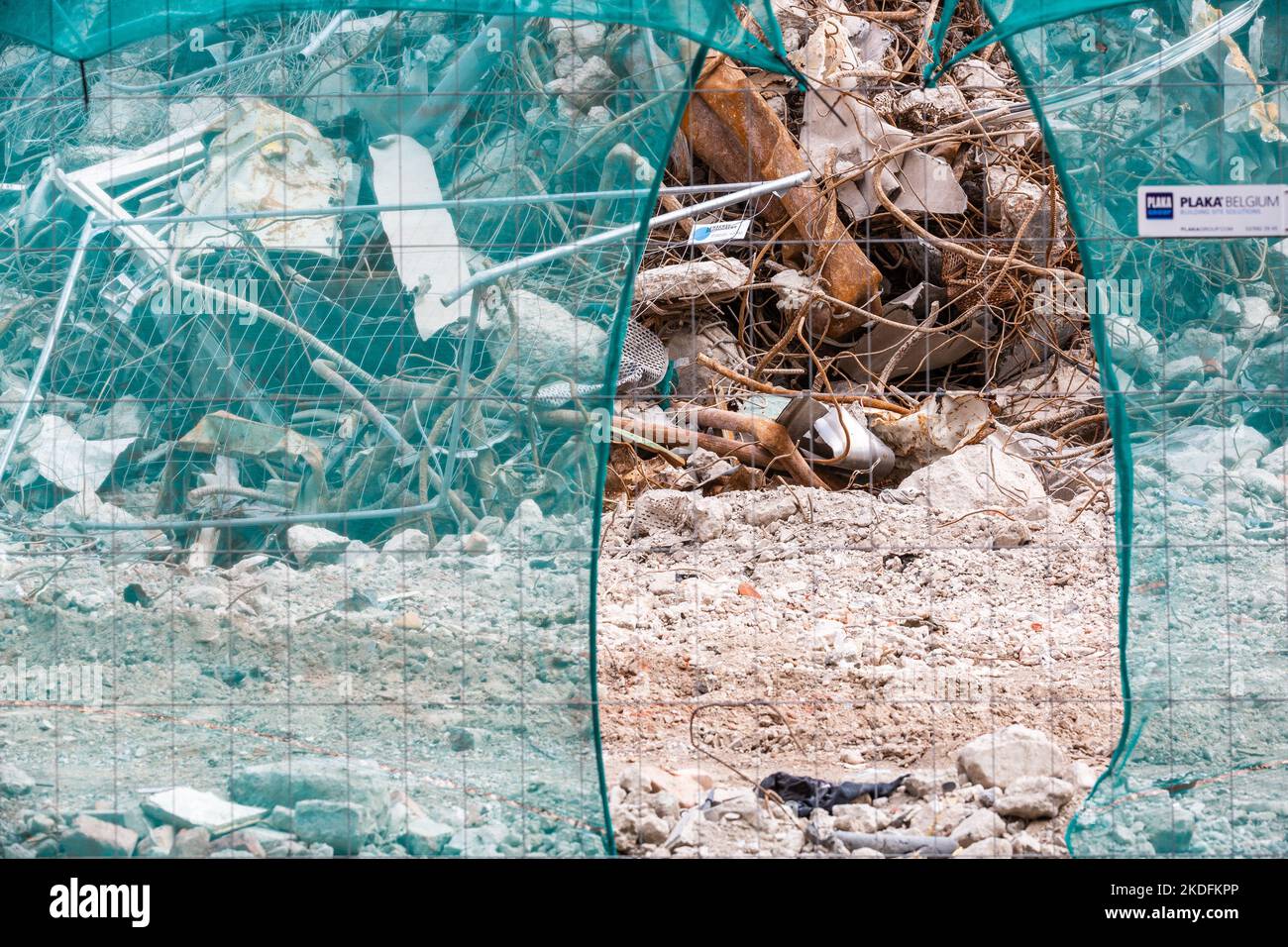 Demolition debris seen through a gap in a drop cloth in front of a ...
