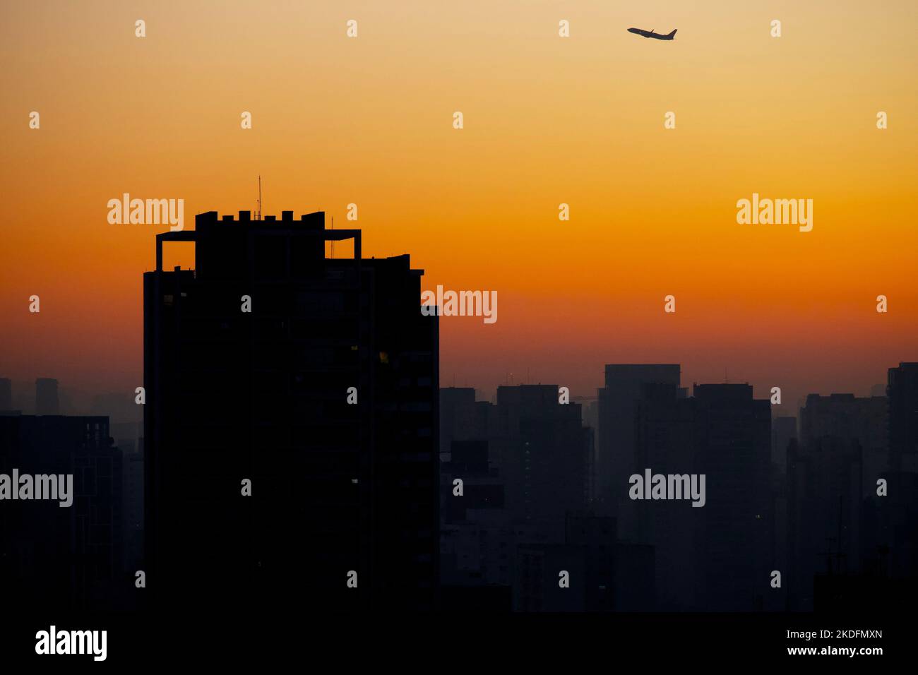 A dramatic sunrise in the big city with a flying airplane Stock Photo ...