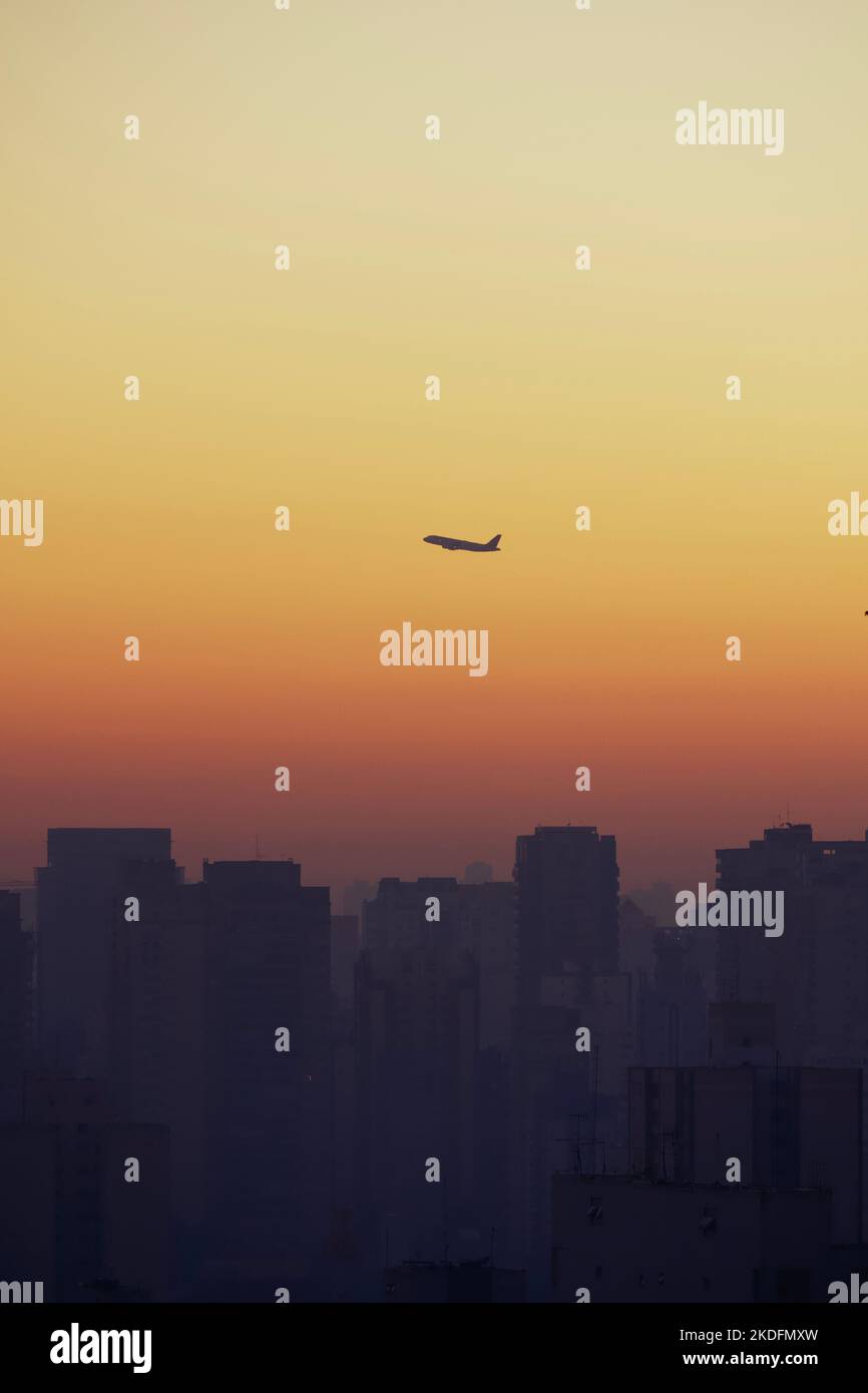 A vertical shot of a dramatic sunrise in the big city with a flying ...