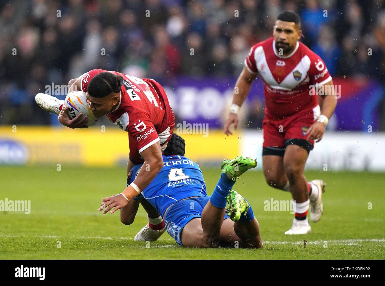 Tonga's Mosese Suli (left) is tackled by Samoa's Stephen Crichton ...