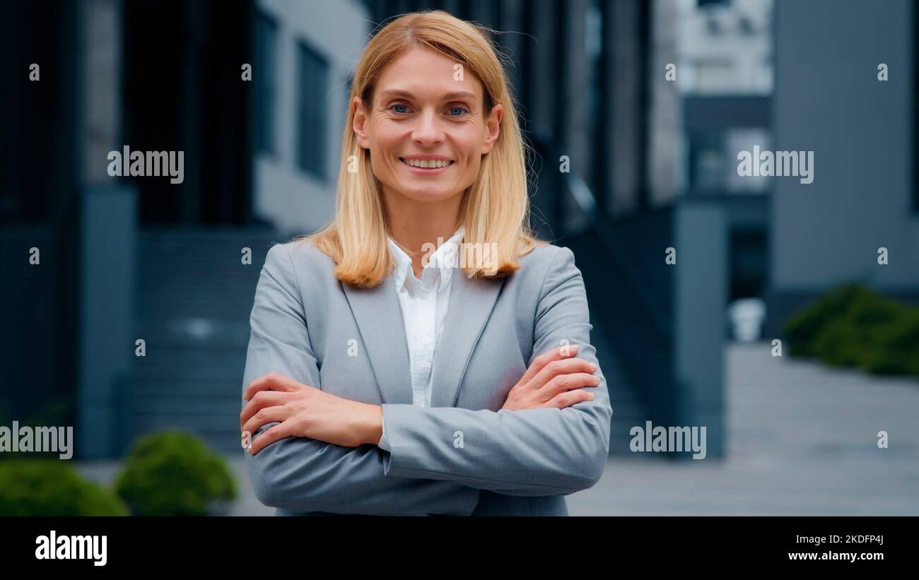 Successful happy young businesswoman walks on street confident proud ...