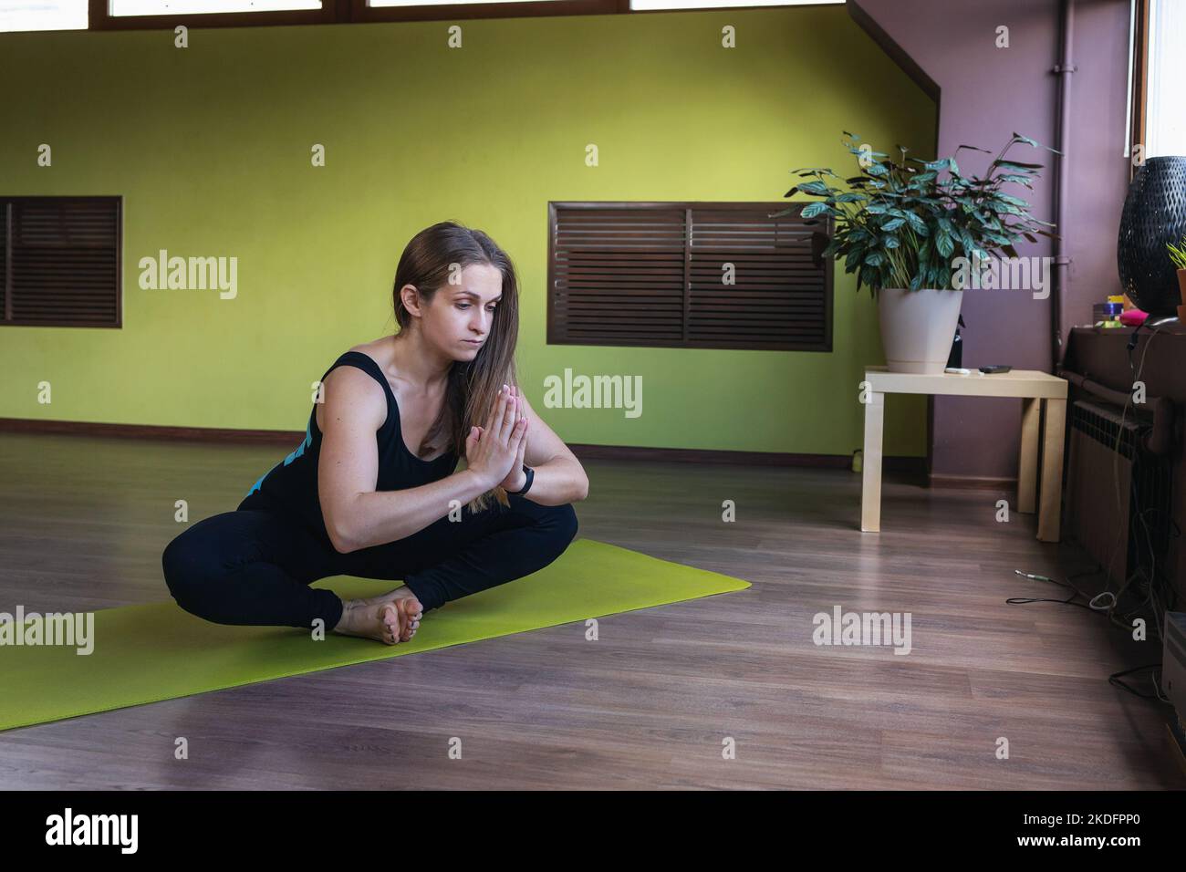A woman practicing yoga doing a variation of the exercise Baddha ...