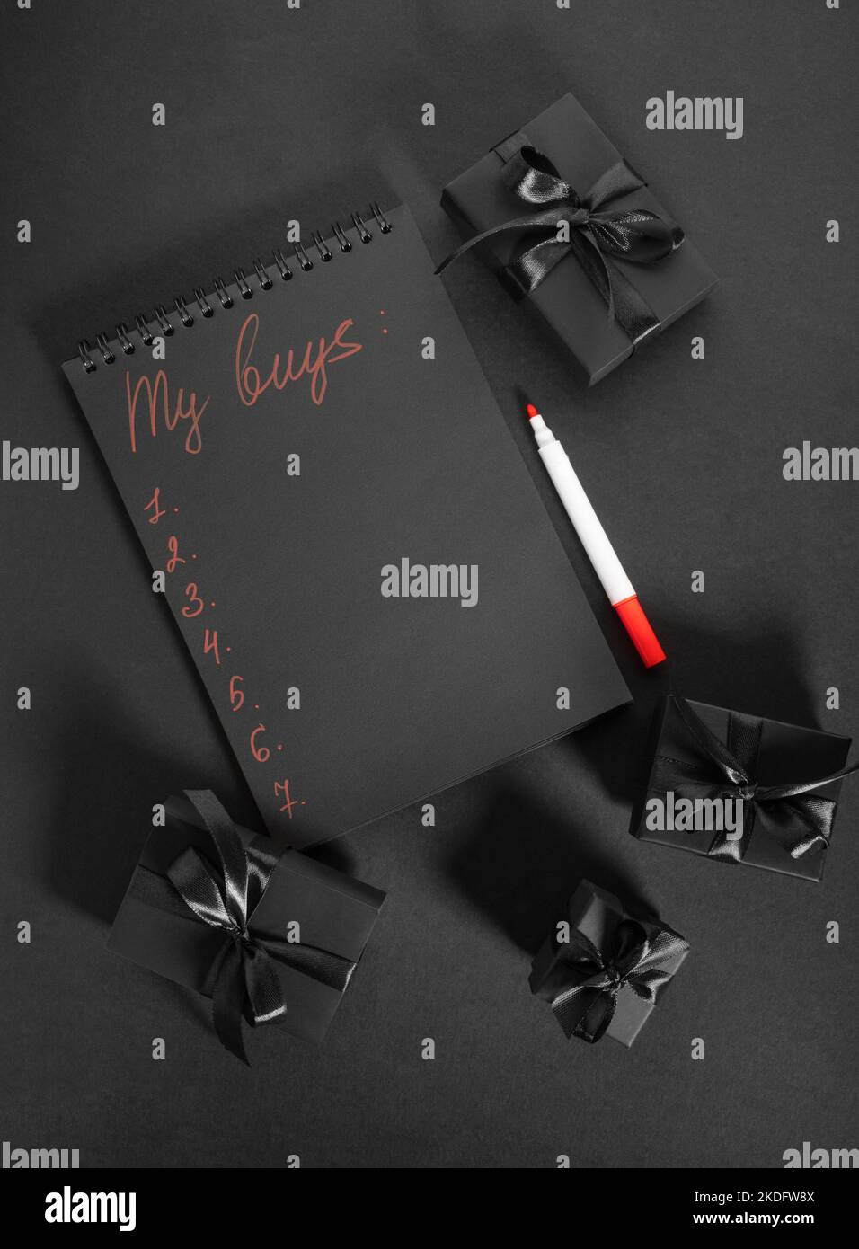 Black notepad with empty page, red MY BUYS text, red pen, black wrapped ...