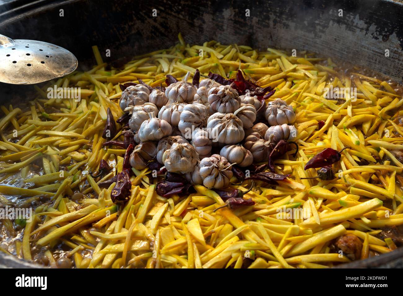 Cooking spicy pilaf in a cauldron. Asian cuisine Stock Photo - Alamy