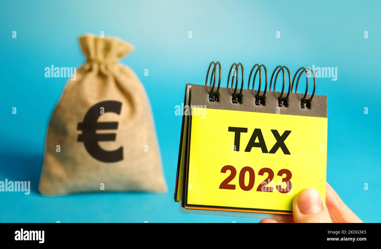 Notes with word Taxes 2023 and euro money bag. The concept of paying ...