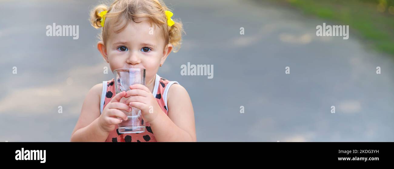 The child drinks water from a glass. Selective focus. Kid Stock Photo - Alamy