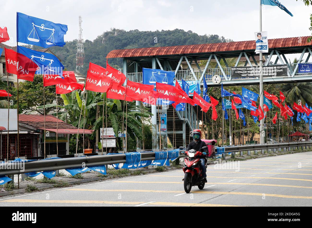 A food delivery rider rides past the political parties flags in Kuala ...