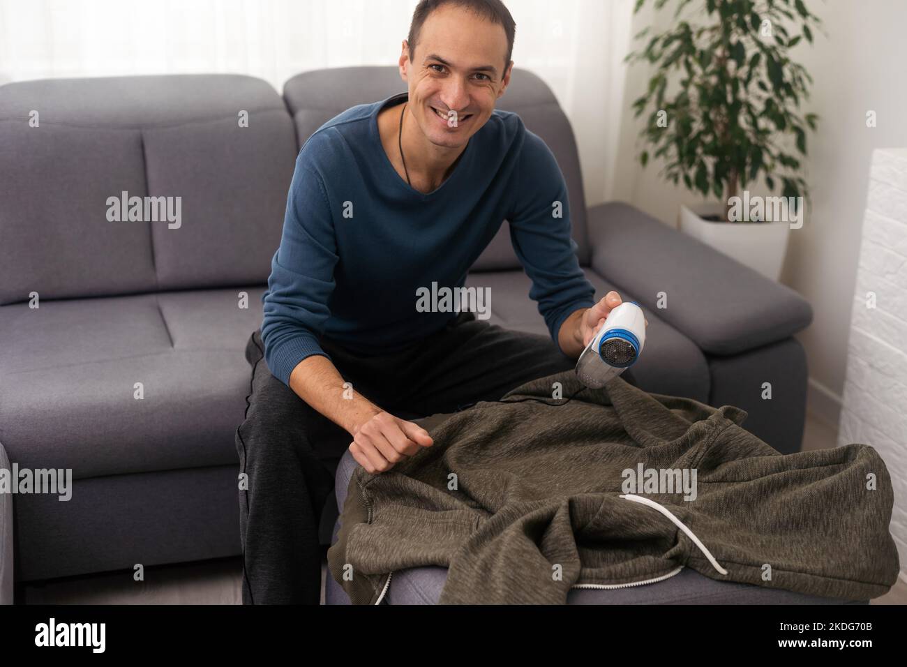 Wireless device for cleaning knitted fabrics from lint. The man is ...