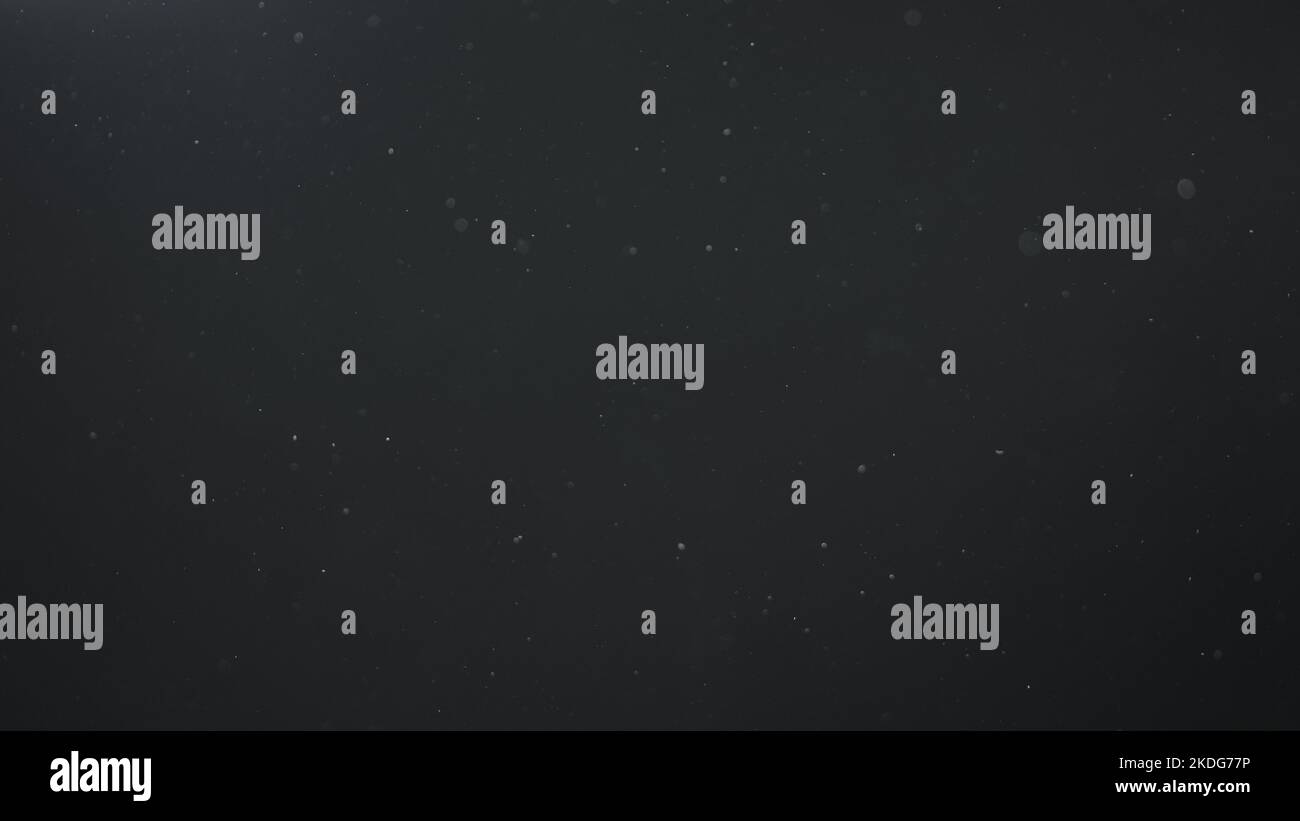 real dust particles in air with back light over black background, wide ...