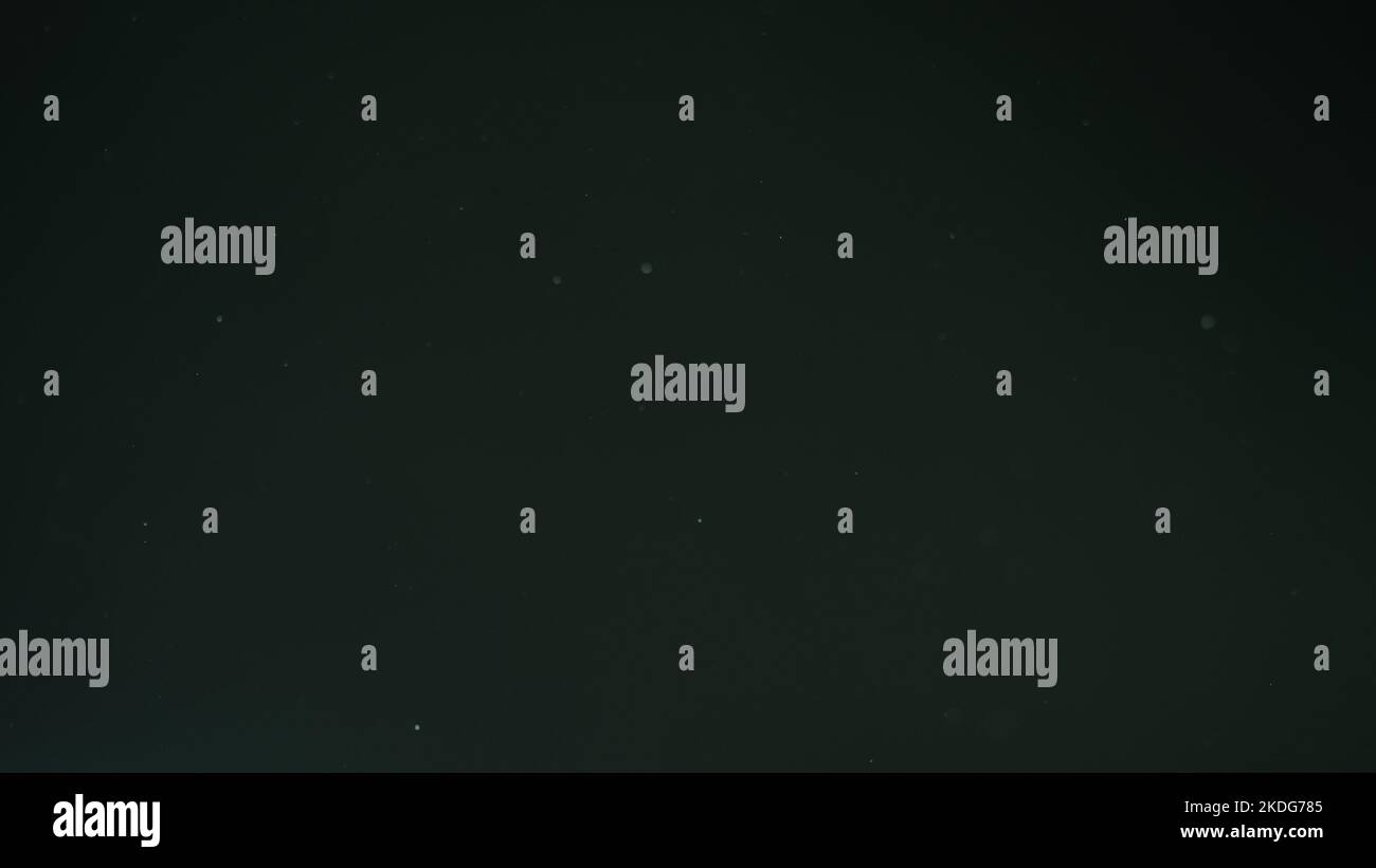real dust particles in air with back light over black background, wide ...