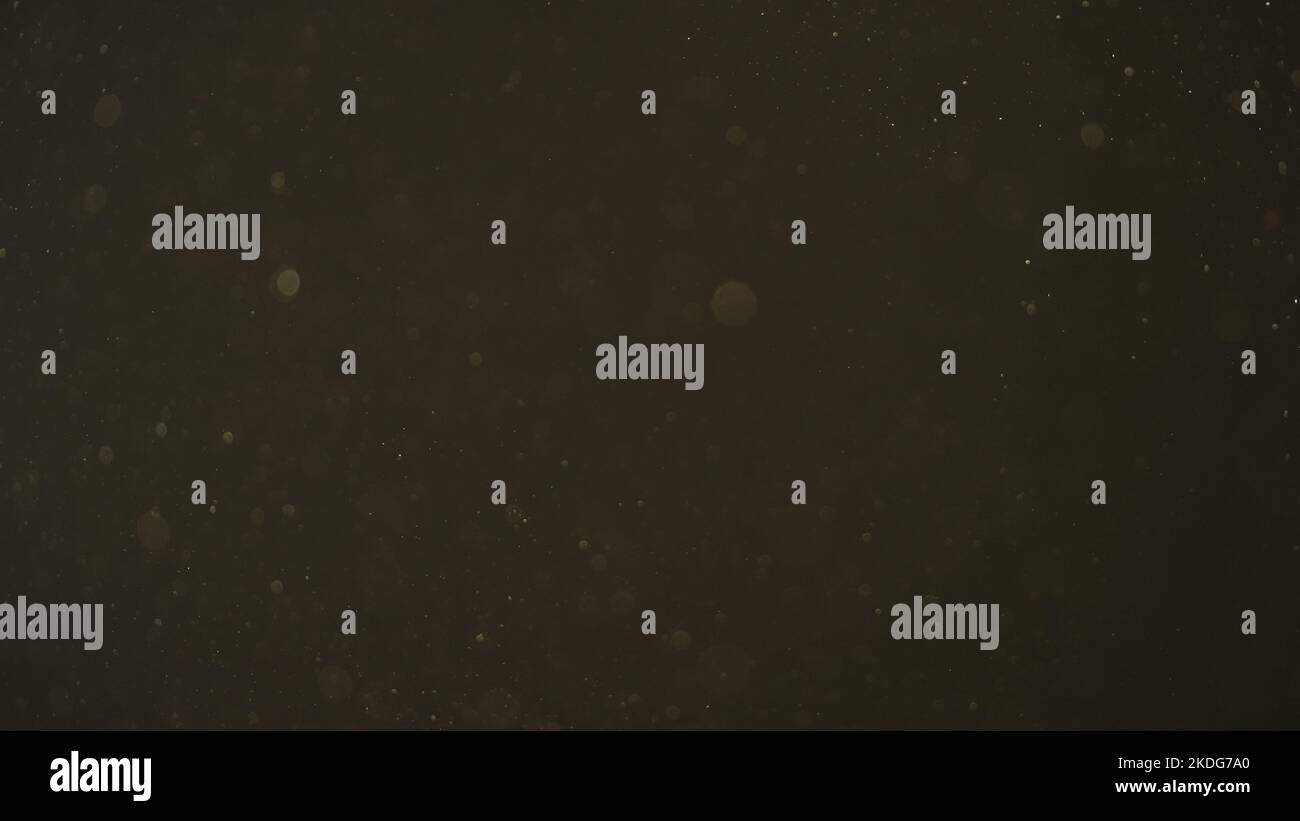 real dust particles in air with back light over black background, wide ...