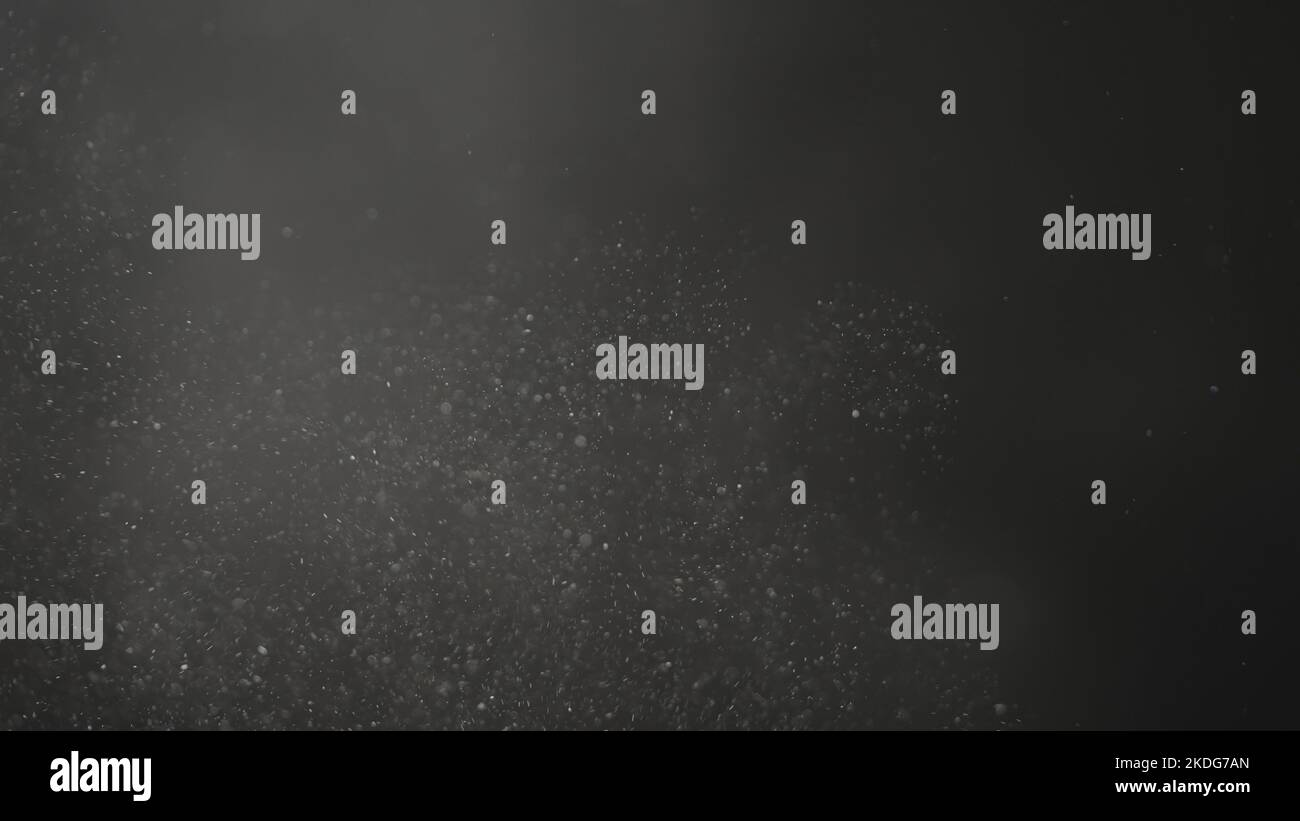 real dust particles in air with back light over black background, wide ...