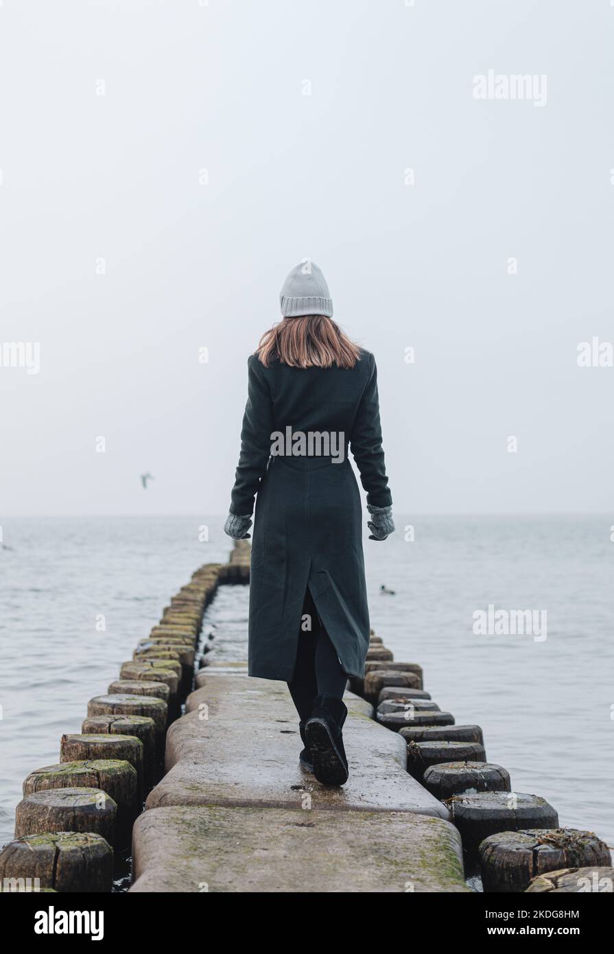 Woman on Groynes in the Baltic Sea during winter Stock Photo - Alamy