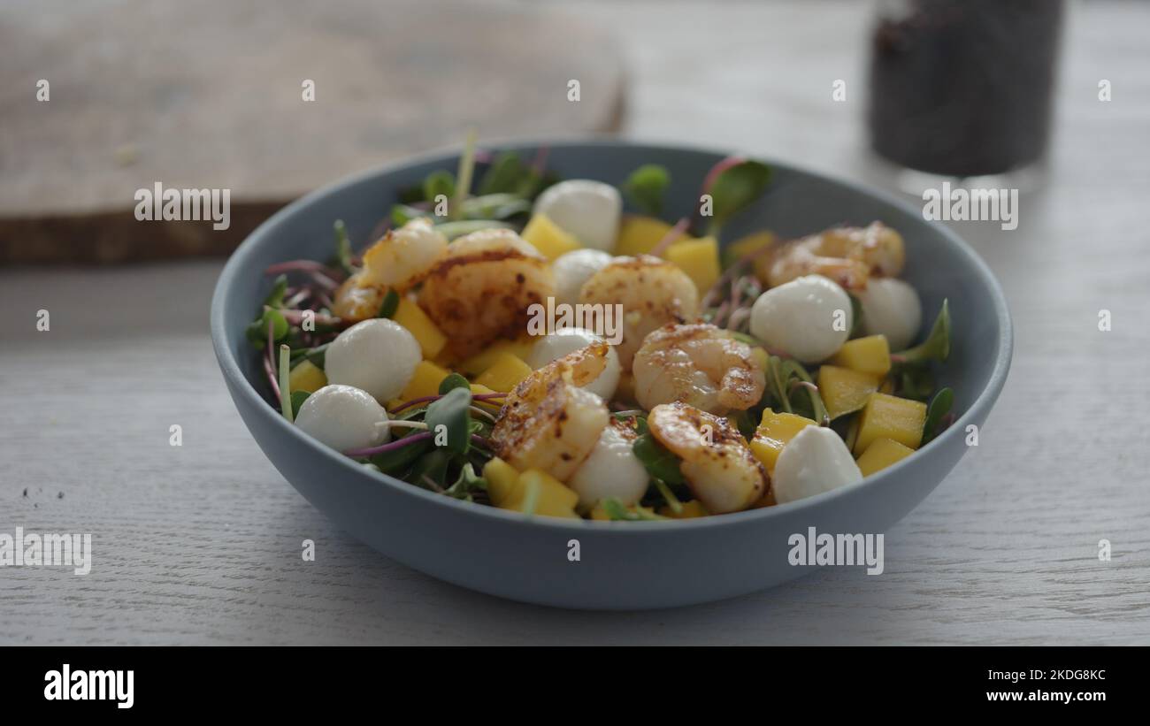 Salad with shrimps, mango, mozzarella and micro greens, wide photo ...