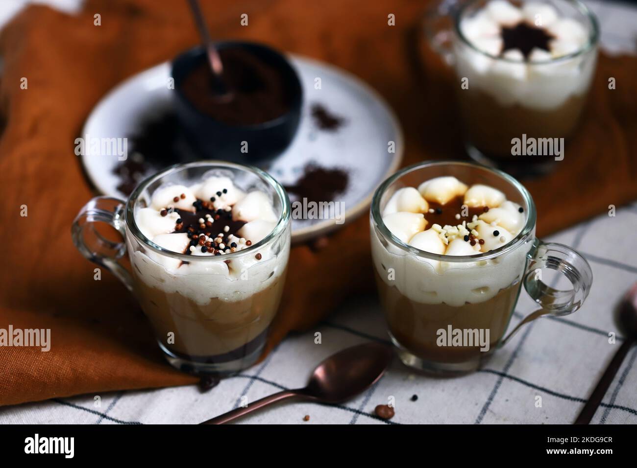 Small mugs with a three-layer coffee-caramel dessert. Delicious pudding ...