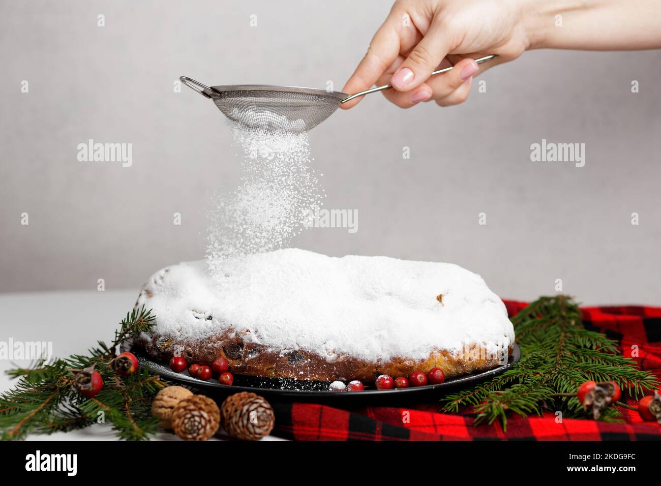 A woman's hand sprinkles powder through a sieve on a German Christmas ...