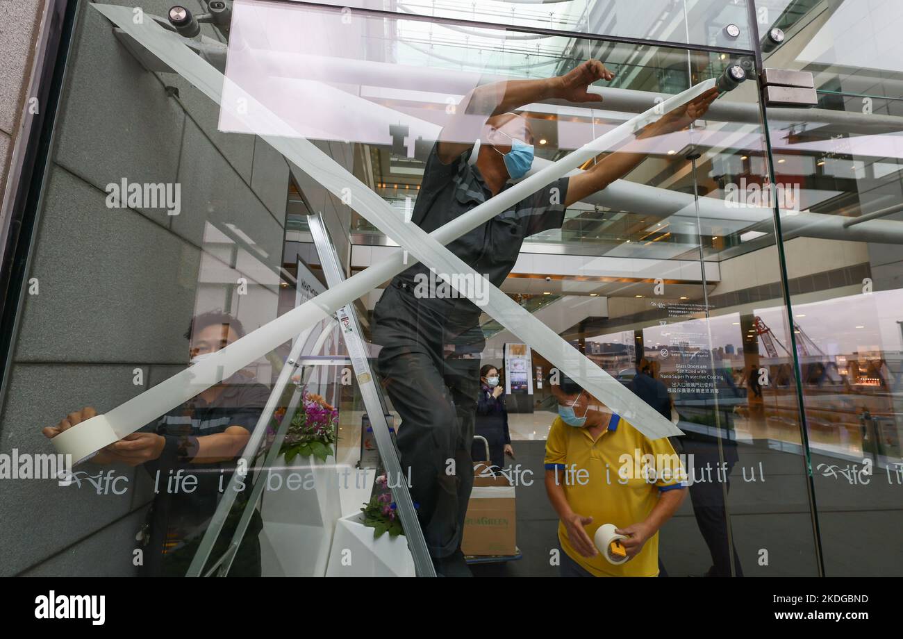 Workers tape glass panels at IFC mall in Central as No 8 storm signal ...