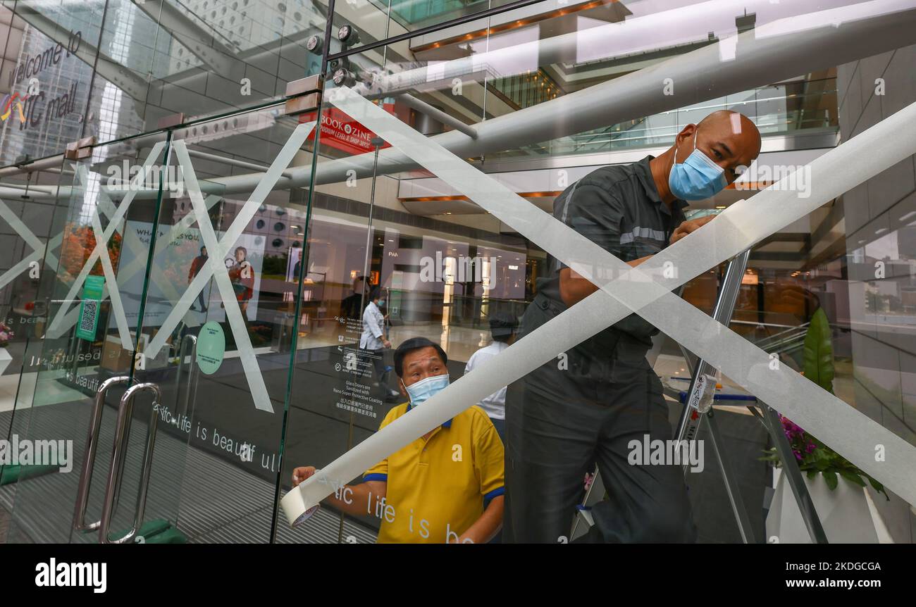 Workers tape glass panels at IFC mall in Central as No 8 storm signal ...
