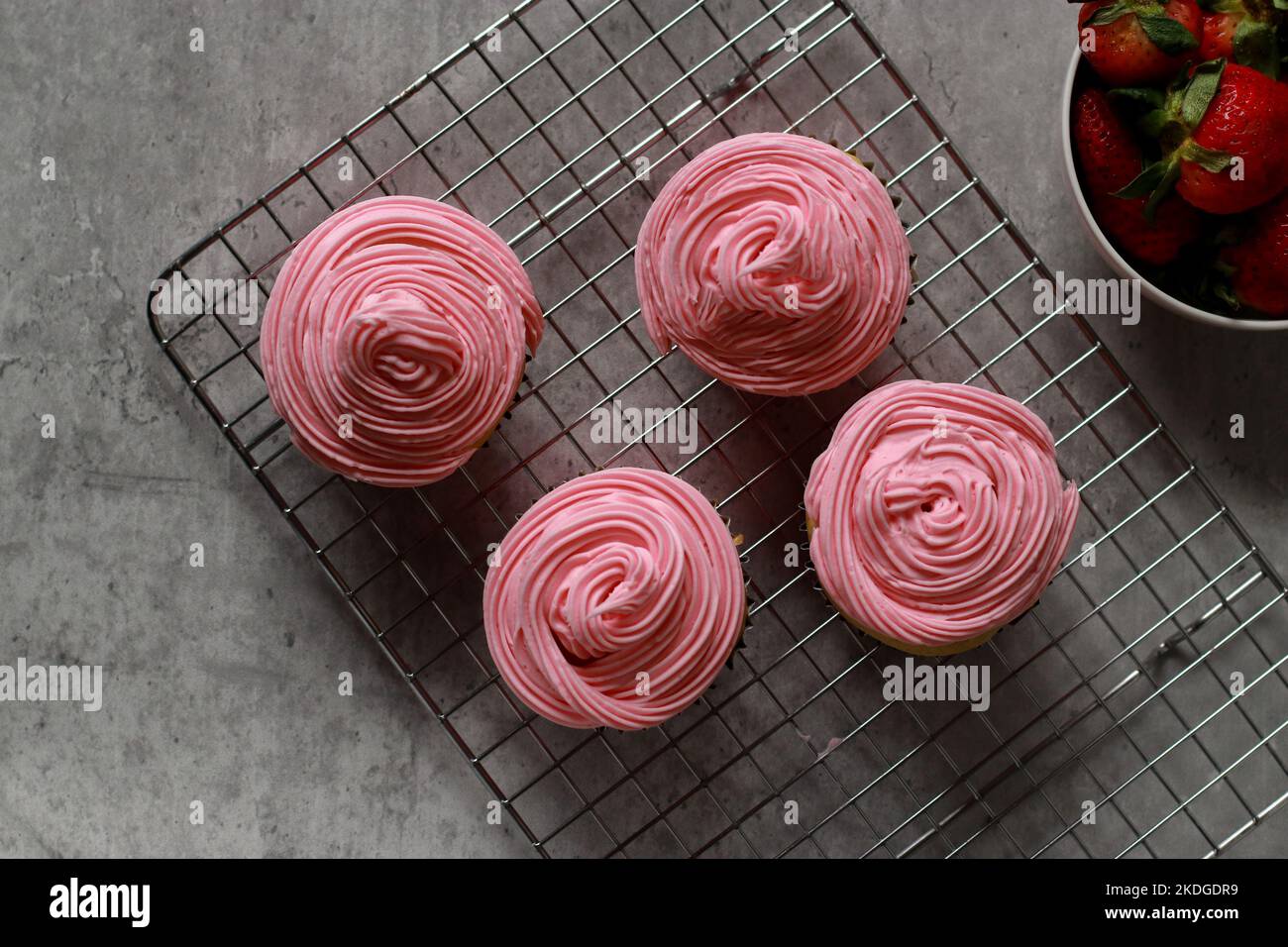 view from above on muffins with pink buttercream frosting on top on ...