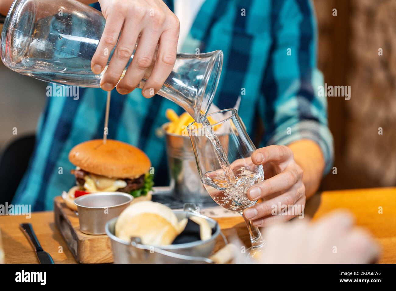 hands pouring water to glass at restaurant Stock Photo - Alamy