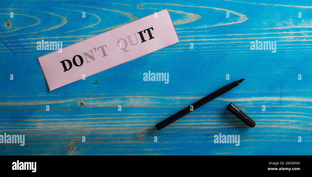 Dont quit sign fading into a Do it sign written on pink paper placed on ...