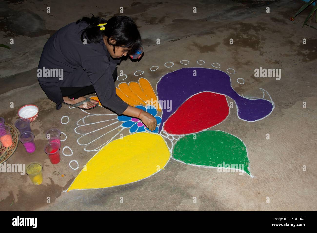 tribal people drawing rangoli on the eve of Diwali Stock Photo - Alamy