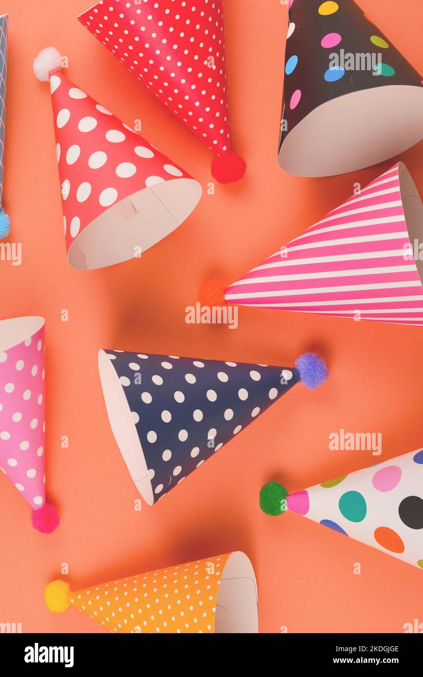 Colorful birthday caps on orange background. Top view Stock Photo - Alamy