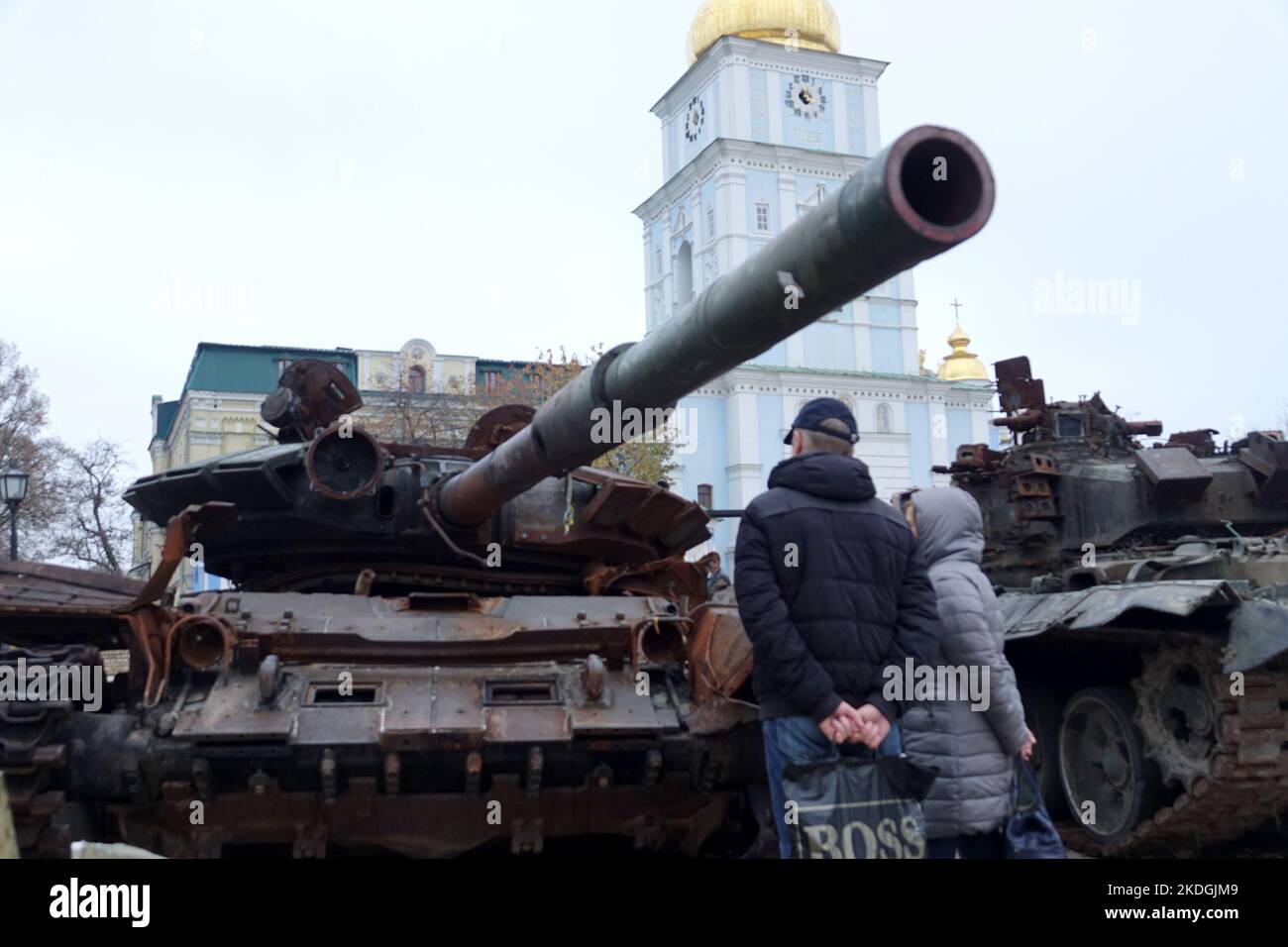 Kiew, Ukraine. 05th Nov, 2022. Passers-by look at a burnt-out Russian ...