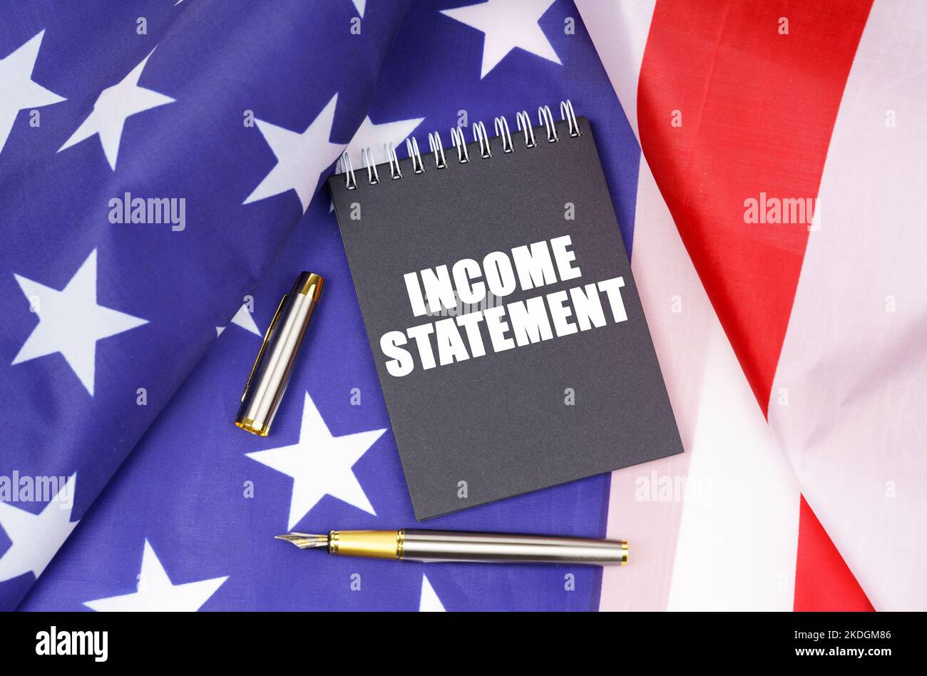 Business concept. On the American flag lies a pen and a notebook with ...