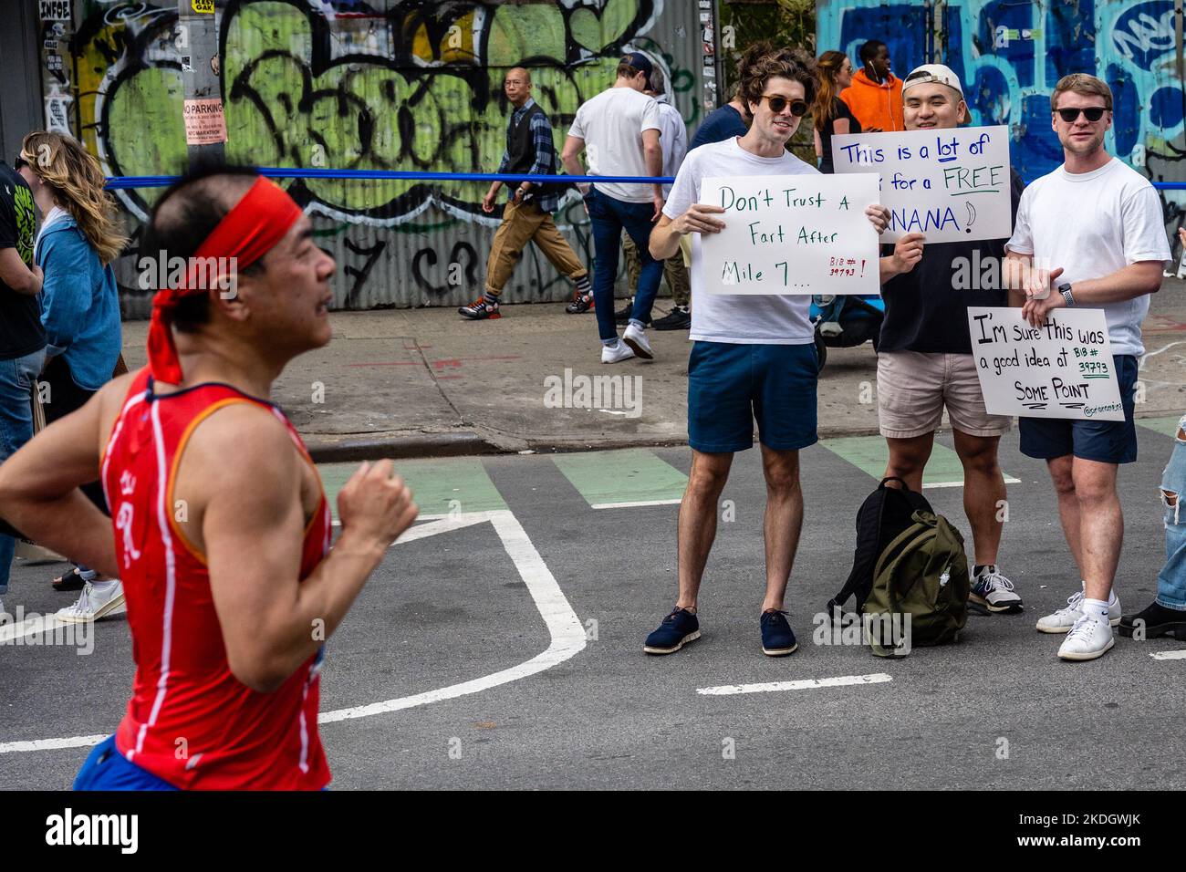 Three guys with funny signs cheer on runners of the NYC Marathon in New ...