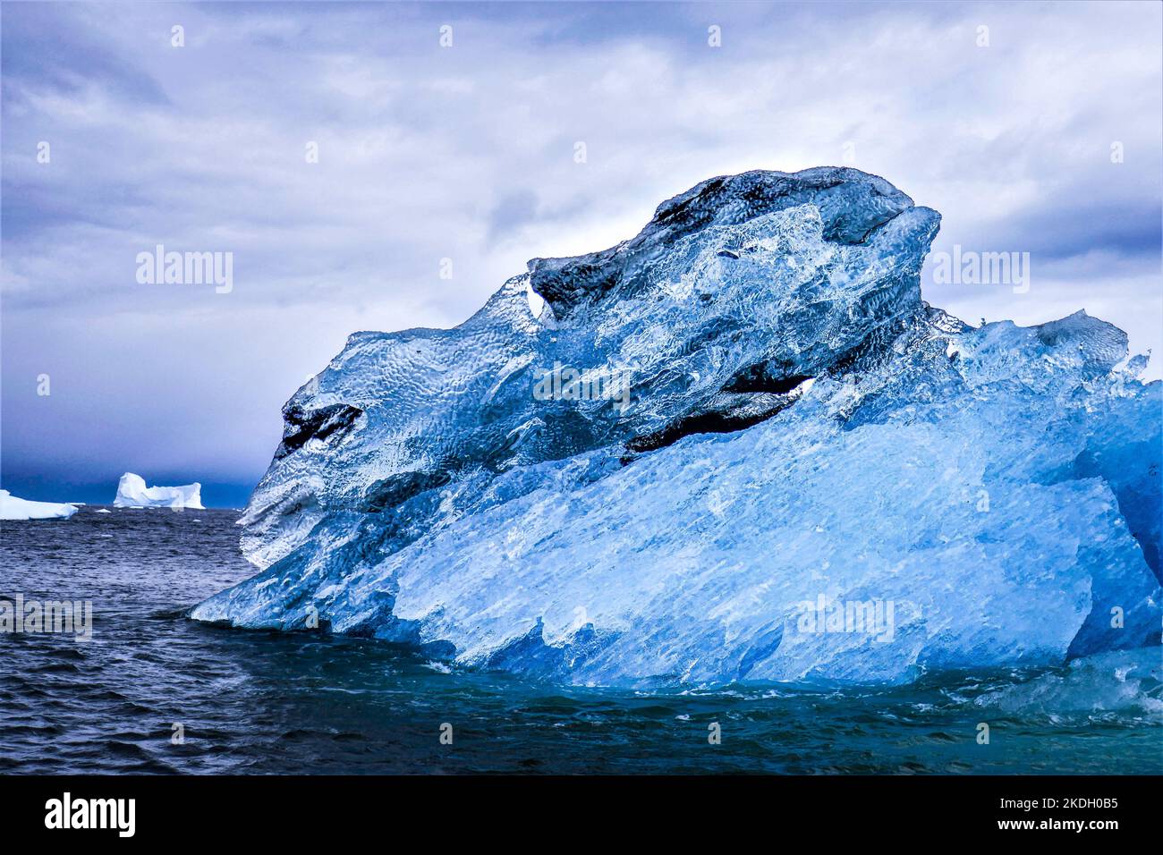 An iceberg of blue ice in Antarctica with an interesting hole / arch ...