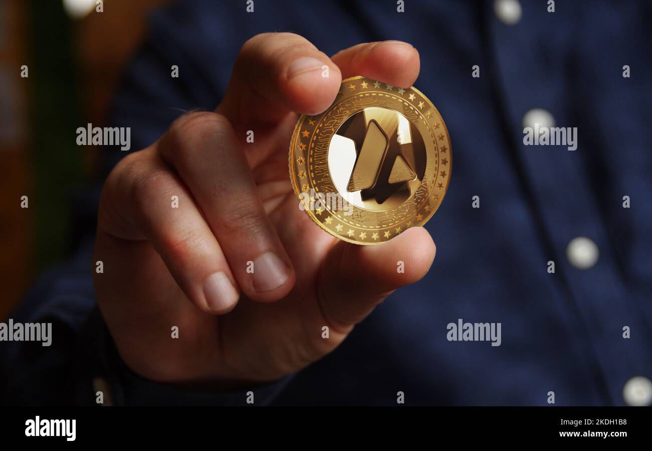 Avalanche Avax cryptocurrency golden coin in hand abstract concept ...
