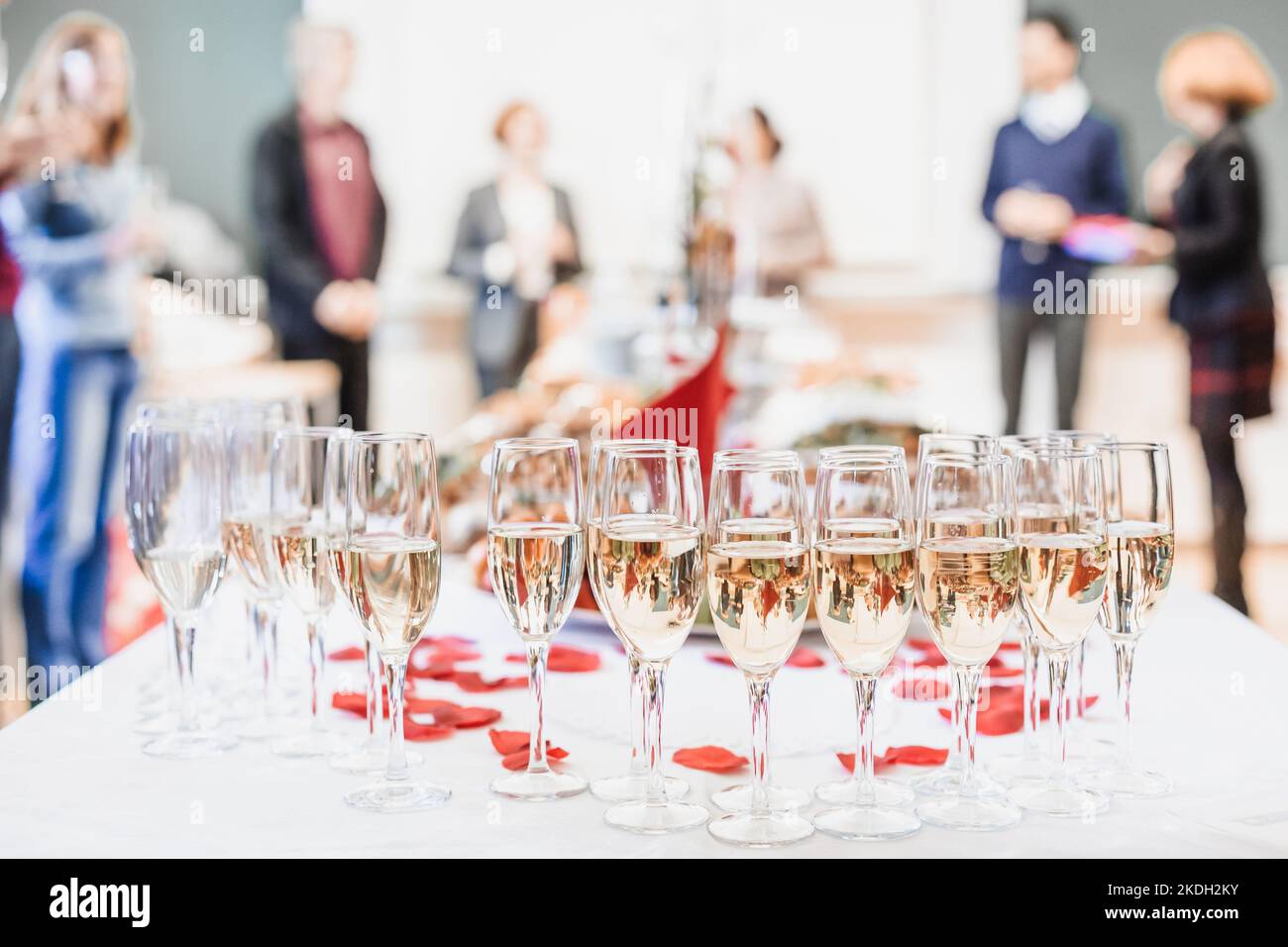 Banquet event. Table with the wineglasses, snacks and cocktails. People ...