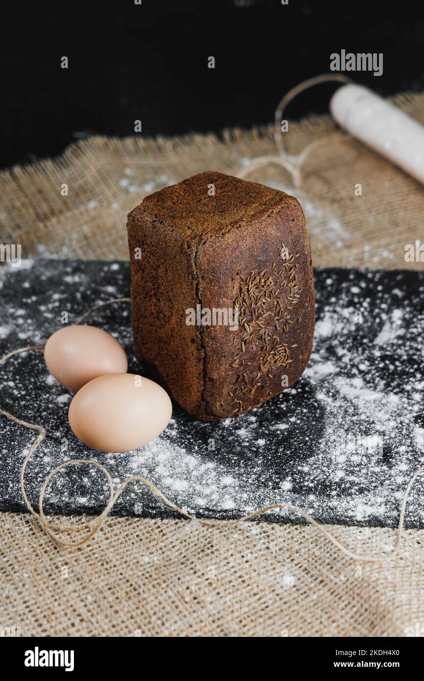 Delicious round rye bread with milk and eggs on a dark background. Crispy fresh bread Stock ...