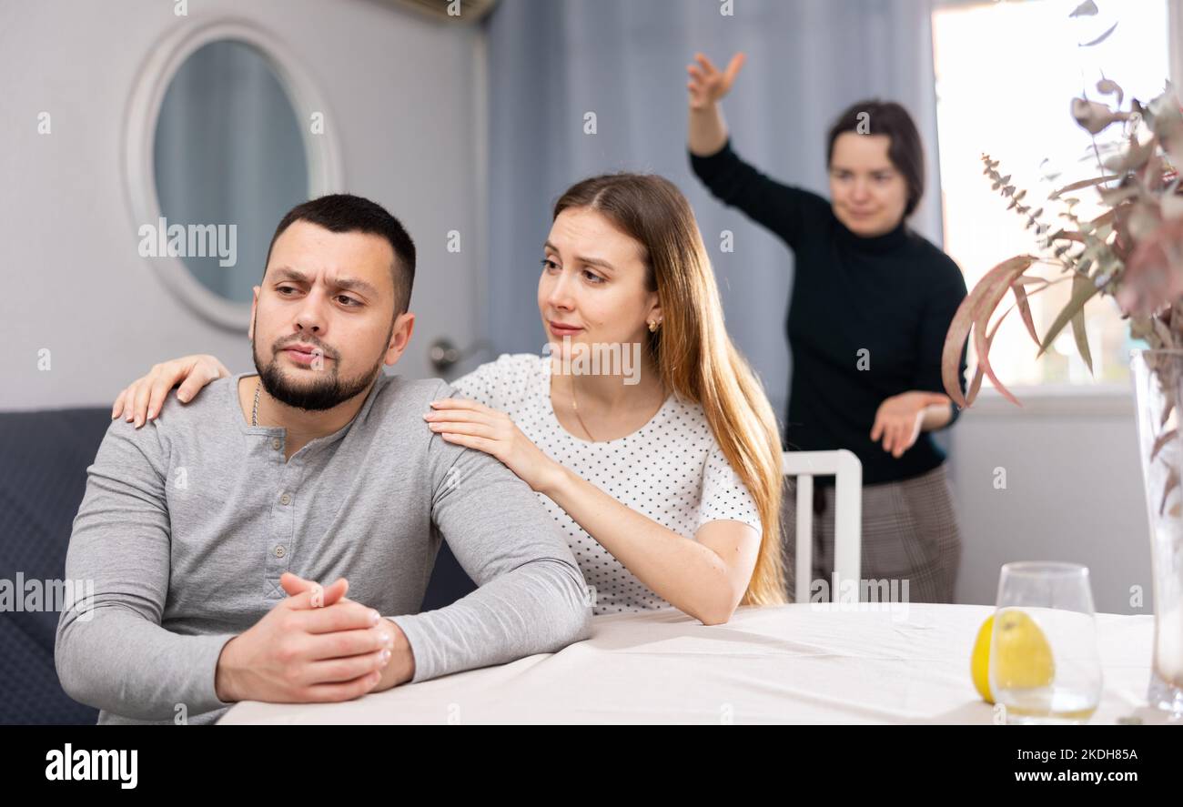 Woman comforting man during quarrel with friend Stock Photo - Alamy