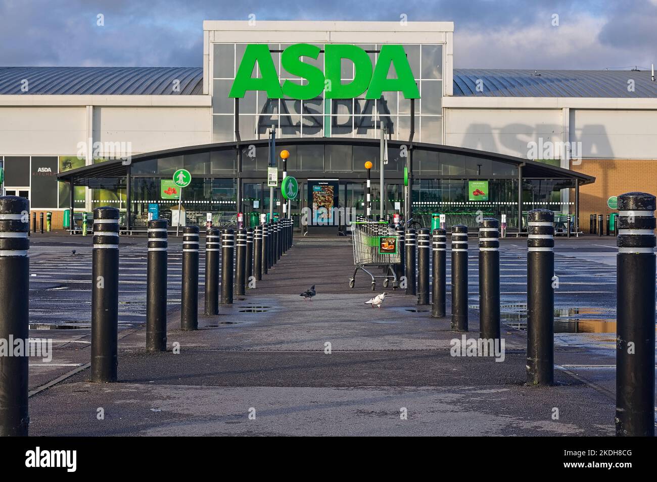 A Deserted Supermarket Entrance With Large Asda Sign And Empty Customer