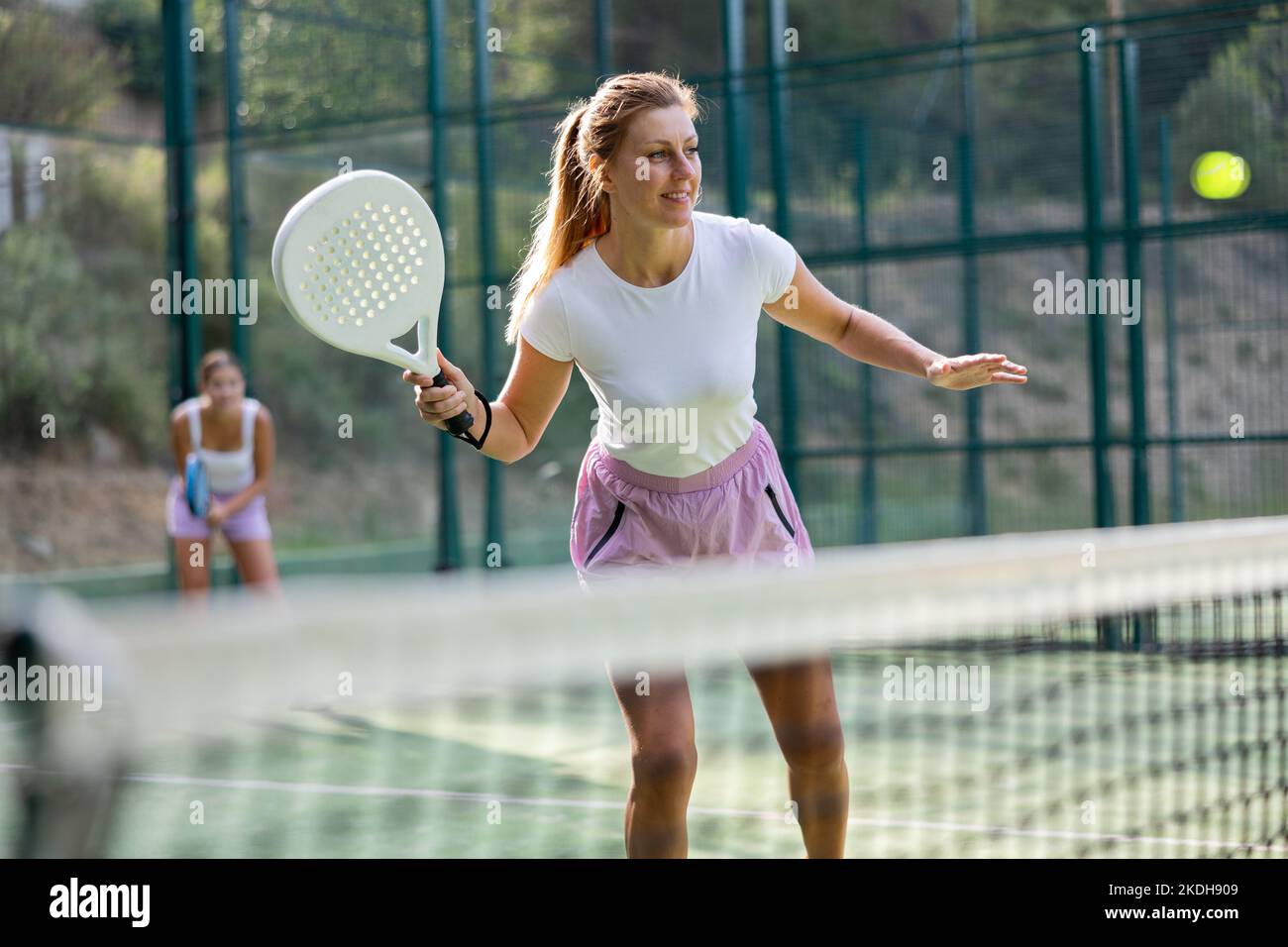 Padel game - woman with partners plays on tennis court Stock Photo - Alamy